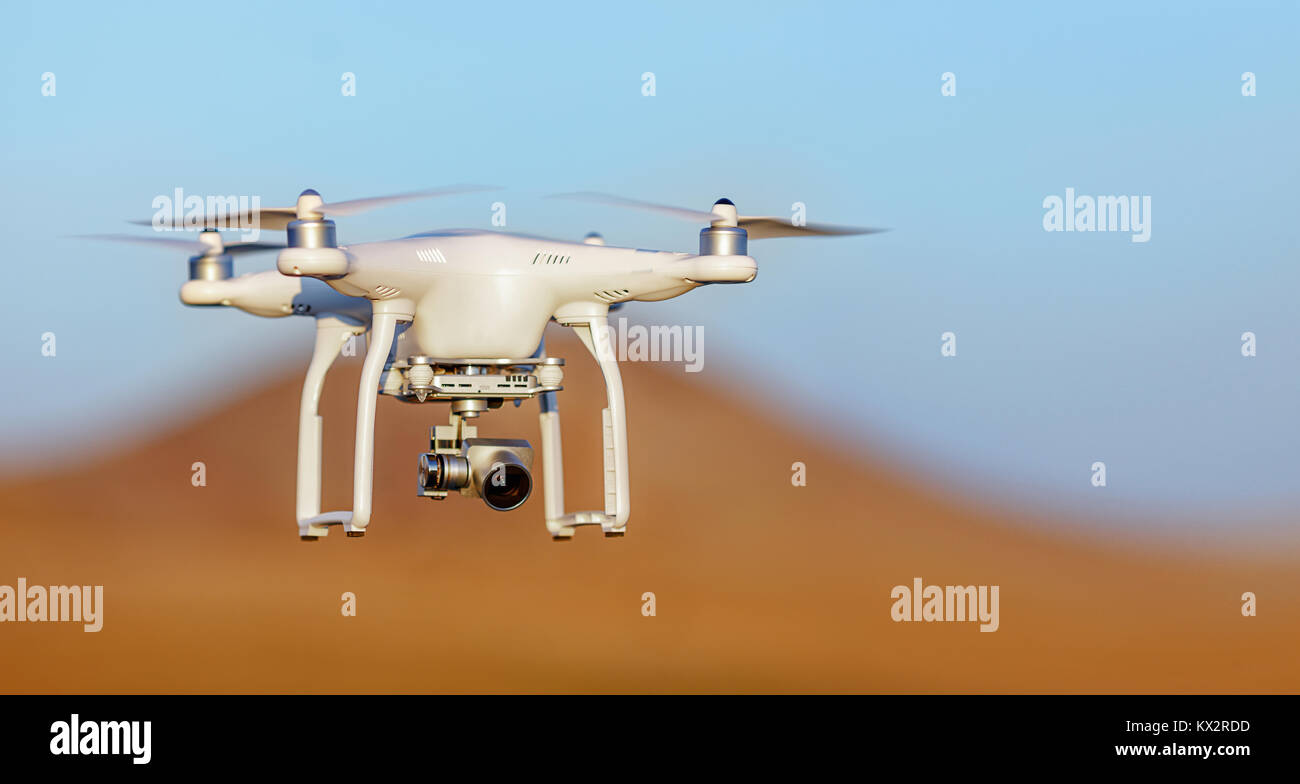 White drone quad copter with high resolution digital camera flying in ...