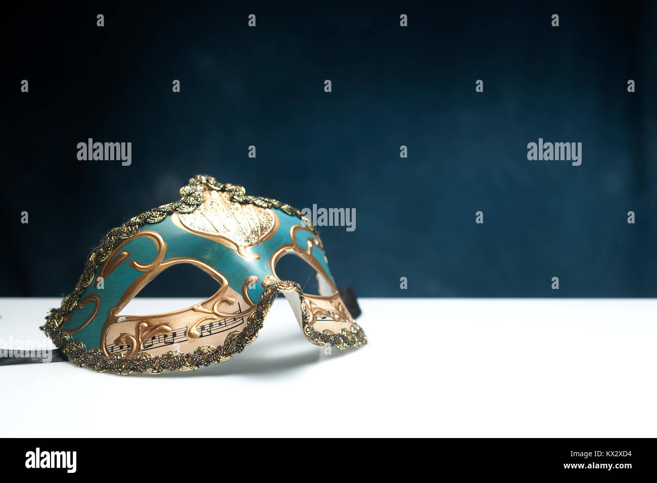 Blue venetian mask on white table with blue background and copy space ...