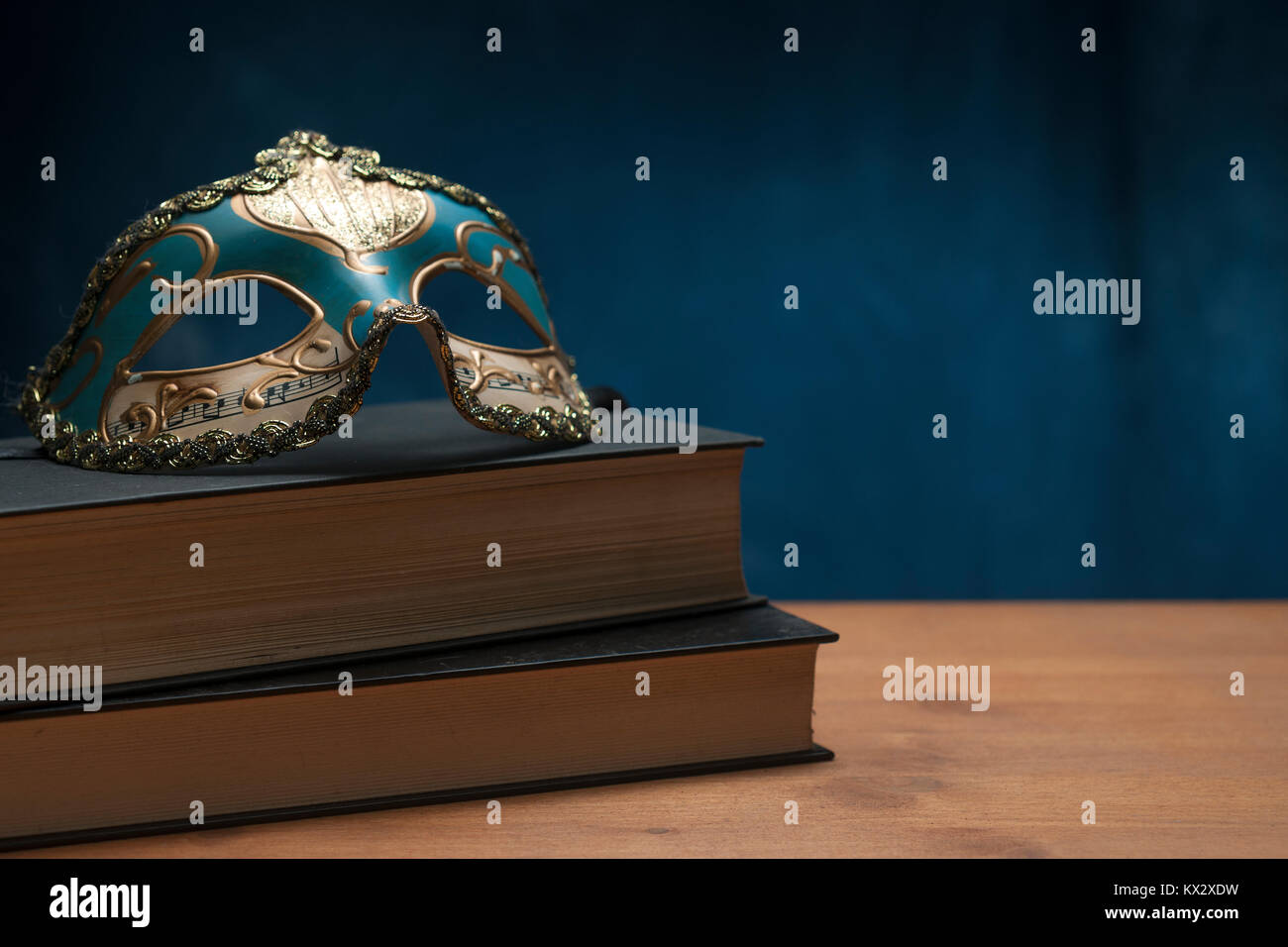Venetian mask on top of books with blue background and copy space Stock ...