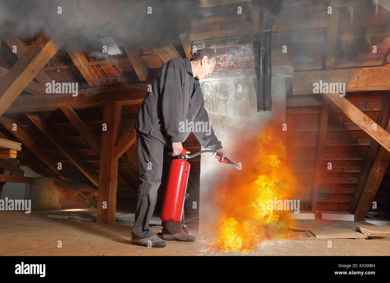 A Man with fire extinguisher fighting agains fire in his house Stock ...