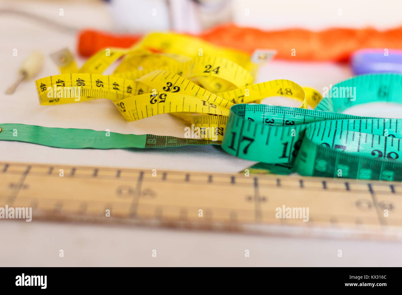 Ribbon meters, a screwdriver and a ruler arranged on a table in a ...