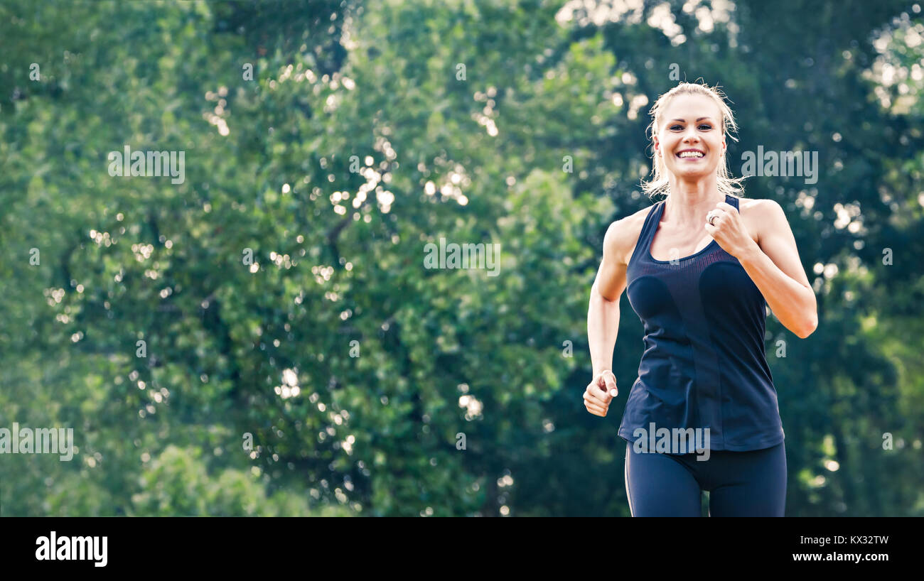 Blonde young woman running in the park Stock Photo - Alamy