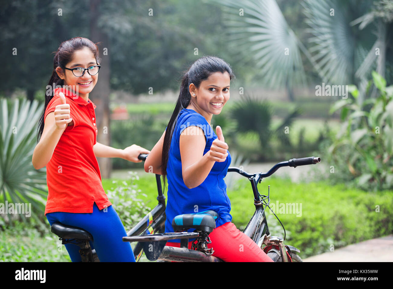 Young Girls Riding Cycle Cycling Park Thumbs up Stock Photo - Alamy