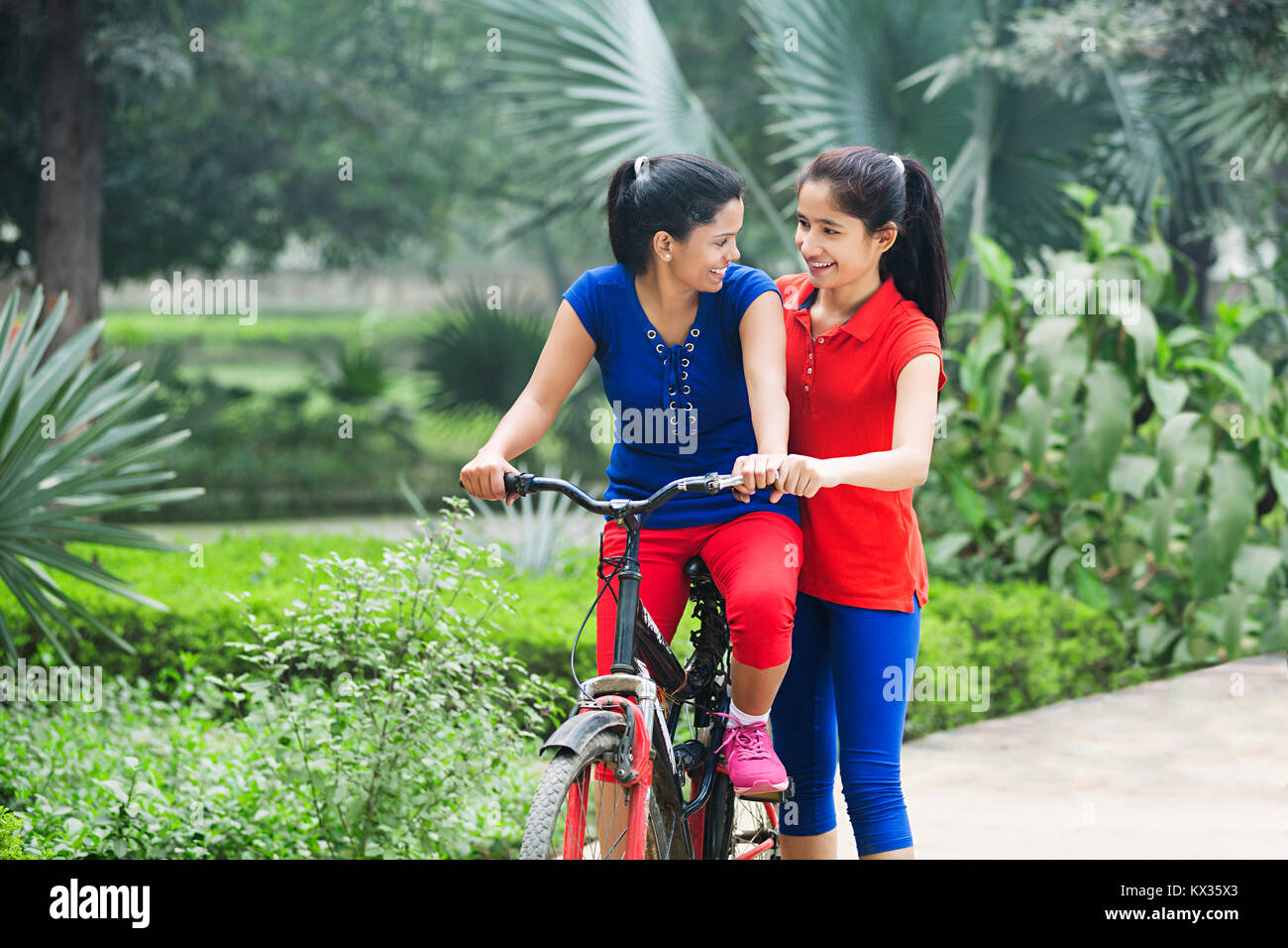 Young Women Friend Riding Bicycle Park Helping Stock Photo - Alamy