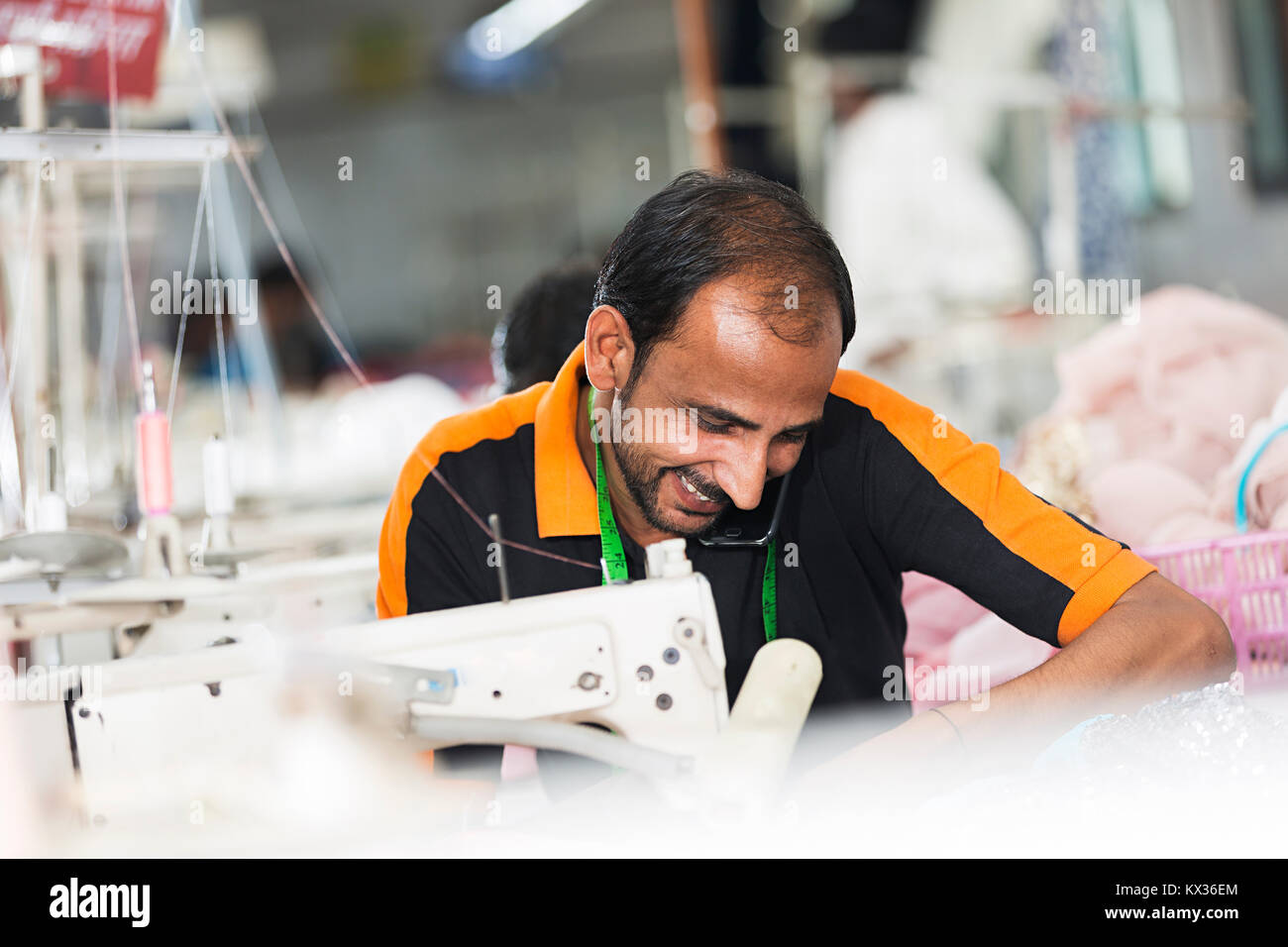 1 Man Worker Tailor Talking Cell-Phone Working In Garment Factory Stock ...
