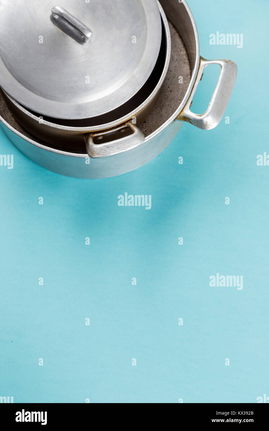 Used home saucepan with scratches on blue paper background Stock Photo ...