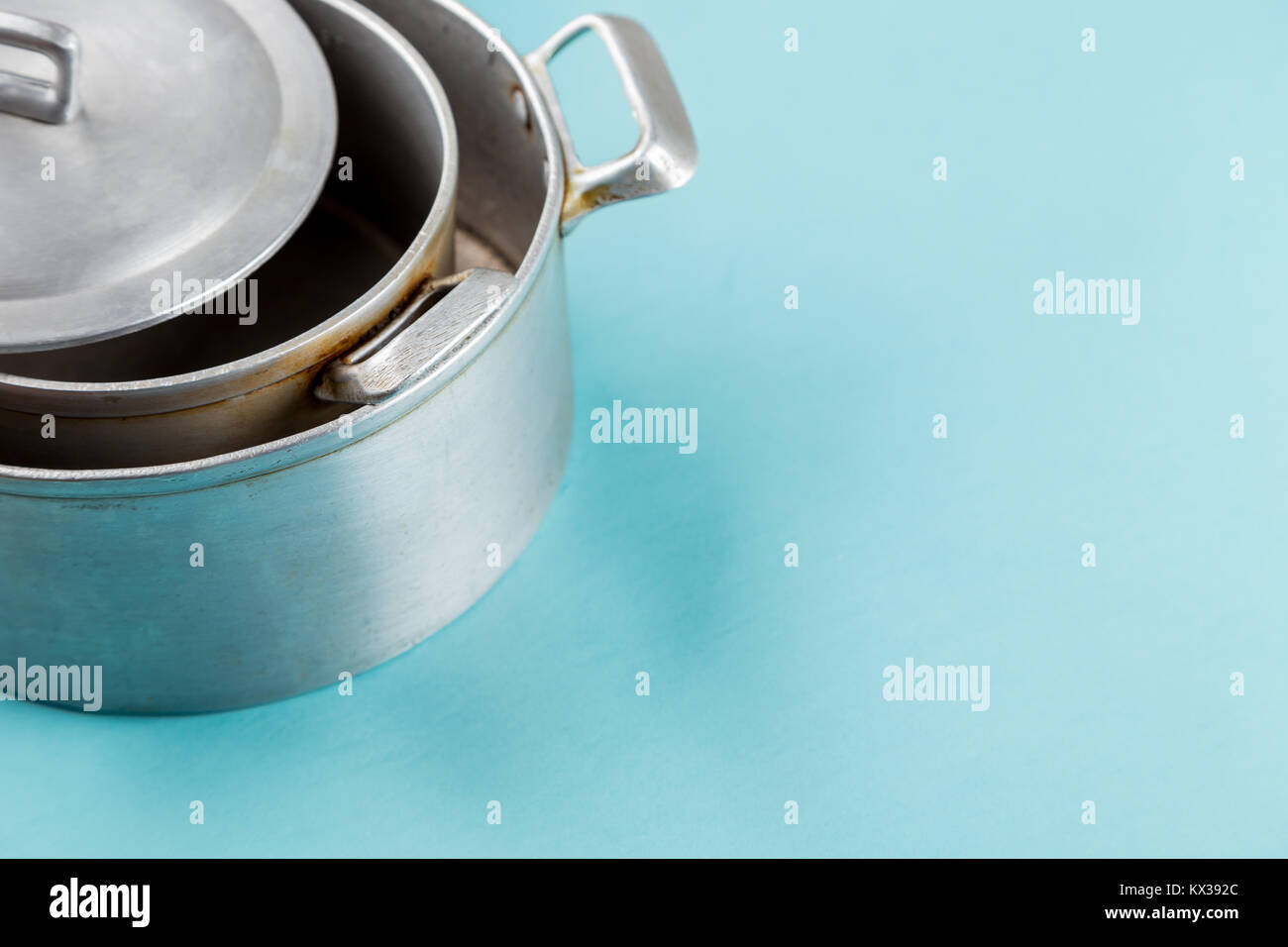 Used home saucepan with scratches on blue paper background Stock Photo ...