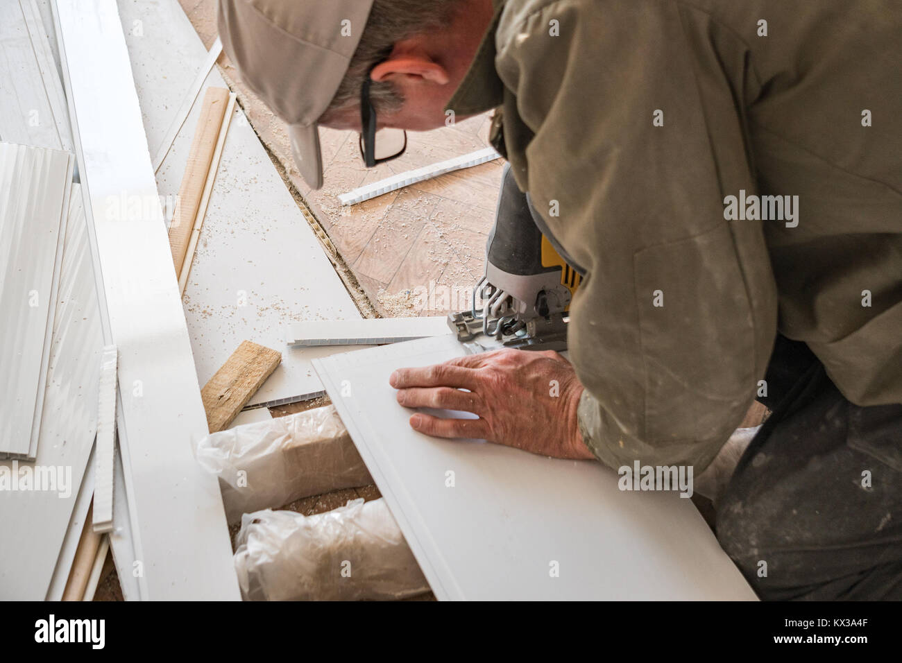 Builder works with white plastic parts Stock Photo - Alamy