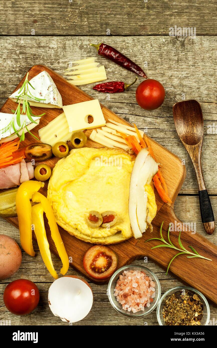 Small egg omelet on the kitchen board. Vegetables and spices Stock ...