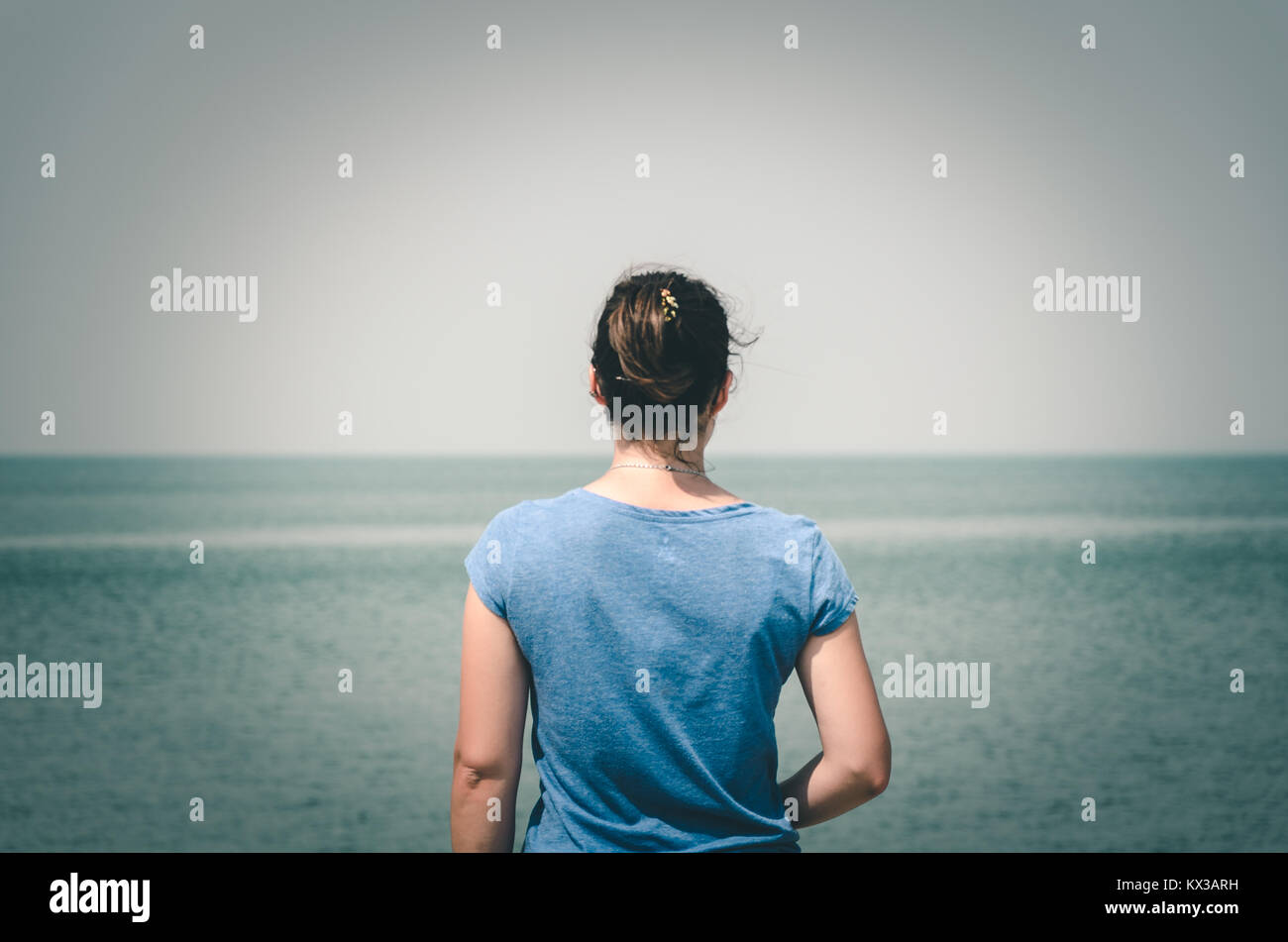 Young woman looking out to sea on a summer's day Stock Photo - Alamy