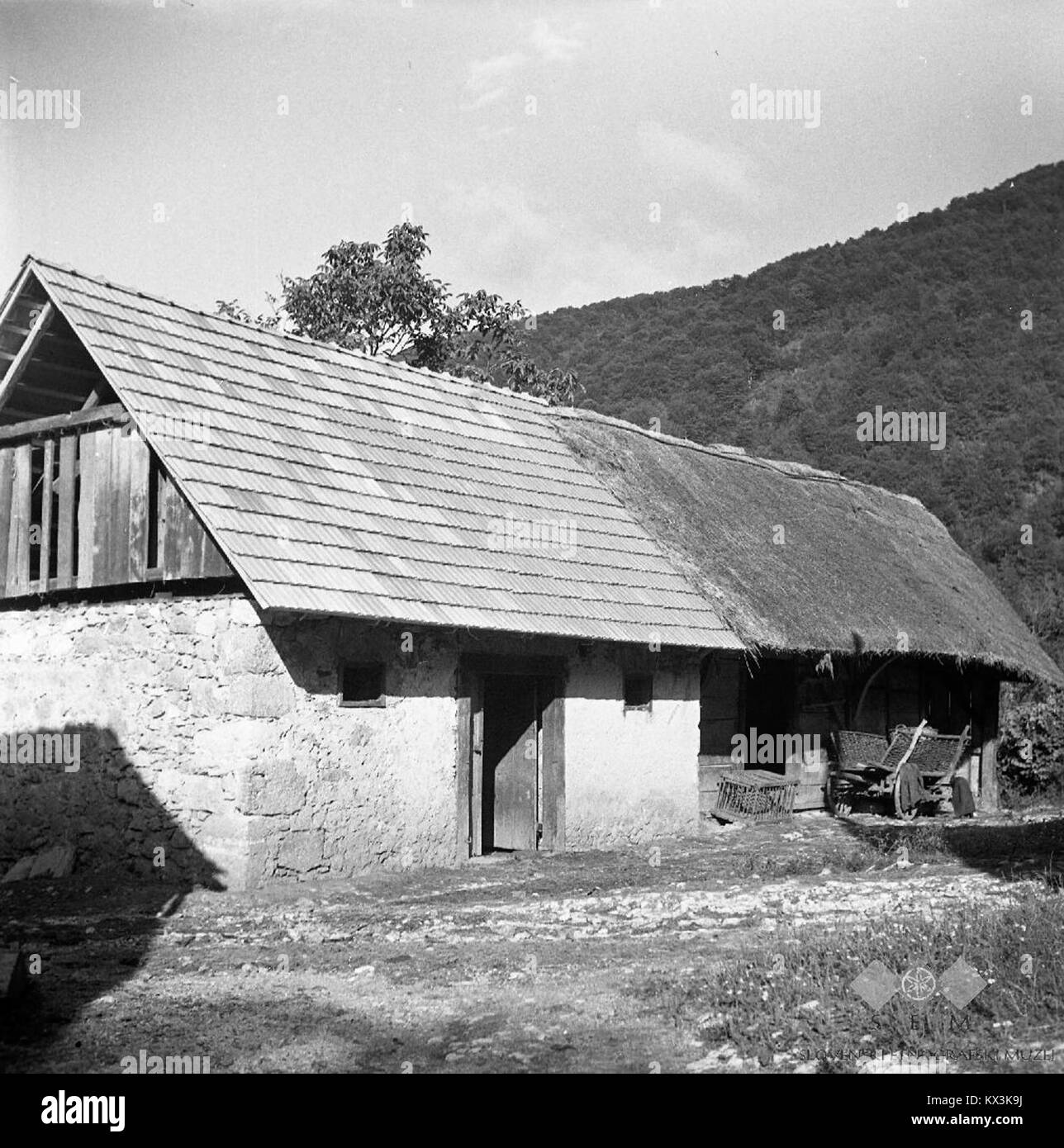This photograph depicts a farm building with a central stall and rear ...