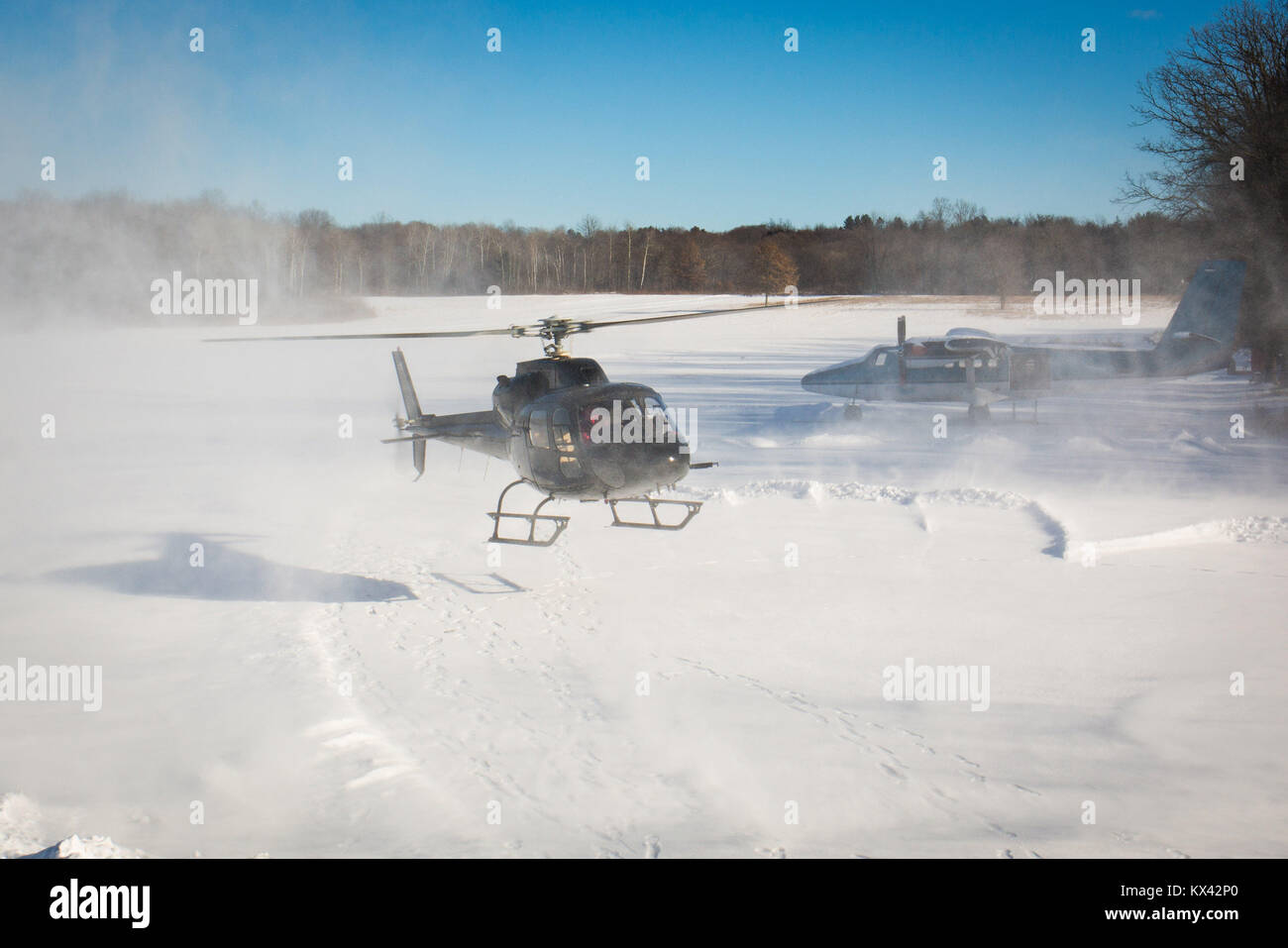 solo black helicopter in blue skies with snow in winter Stock Photo - Alamy