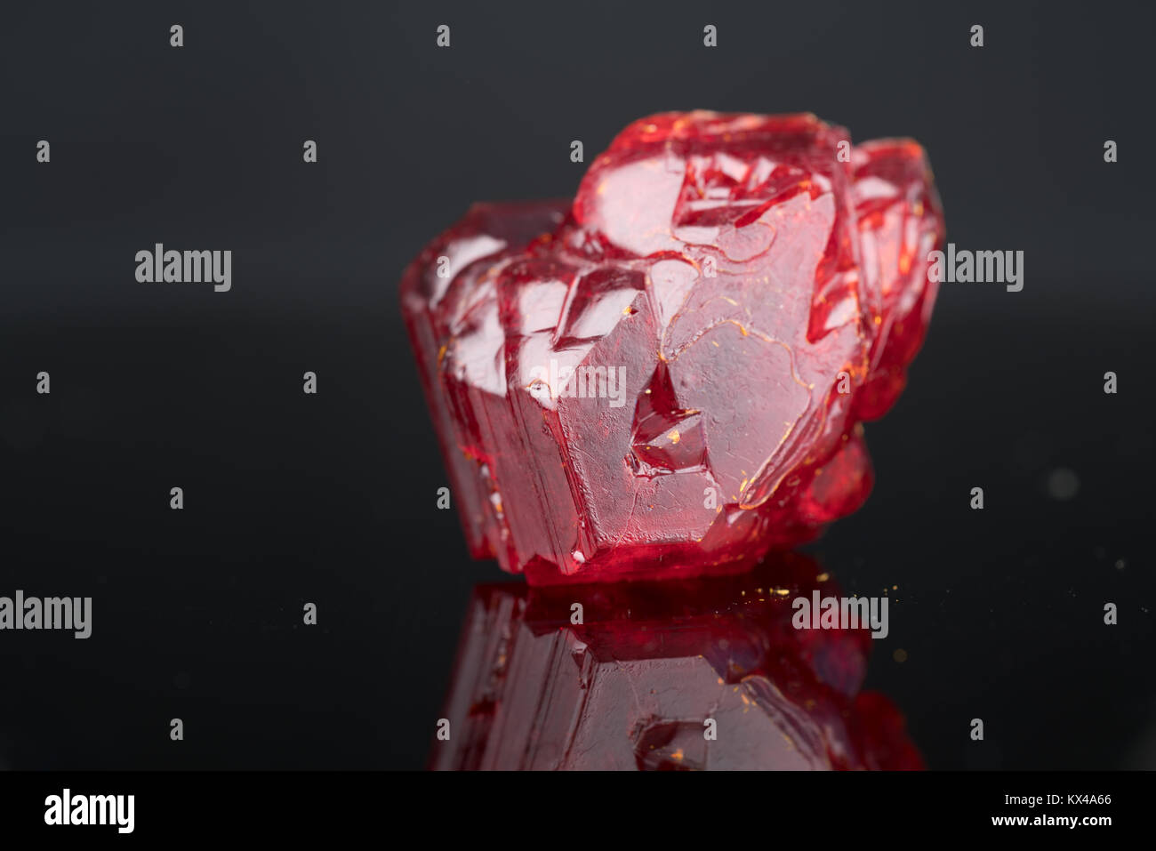 Red natural crystal mineral on a black background Stock Photo - Alamy