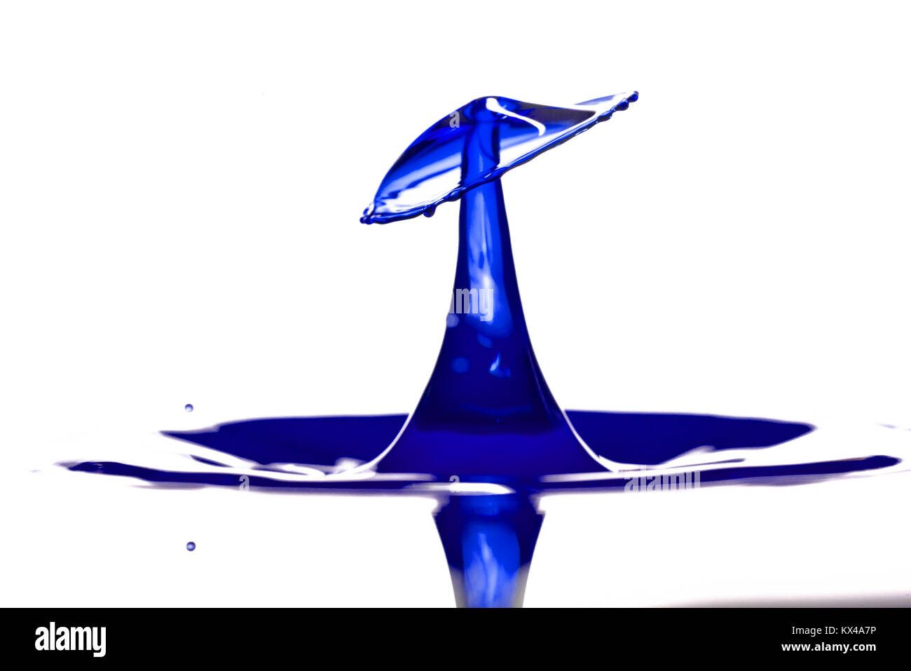 Splash and crown on rippled blue liquid or water surface . Water splash ...