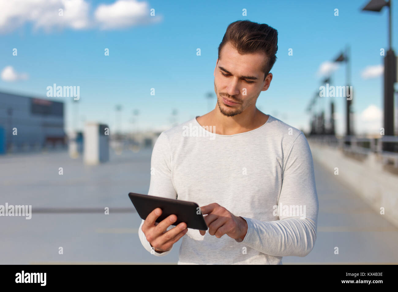 Young caucasian man pushing screen on digital tablet outdoor, empty ...