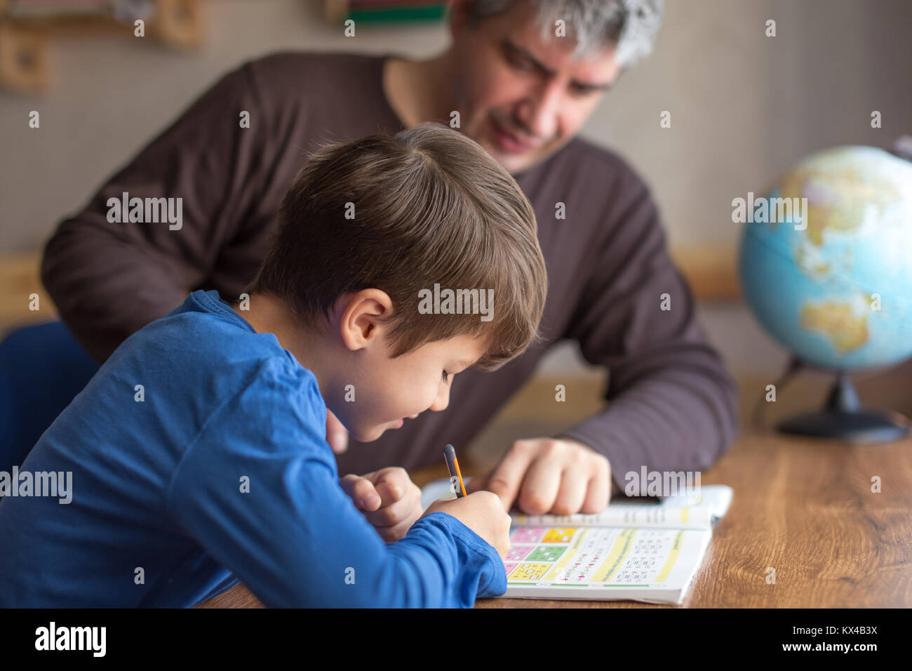 Caucasian father and son doing mathematics homework at desk Stock Photo ...