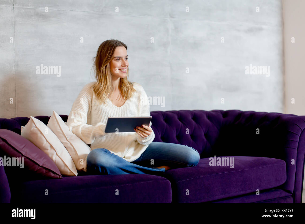 Young woman with digital tablet on sofa Stock Photo - Alamy