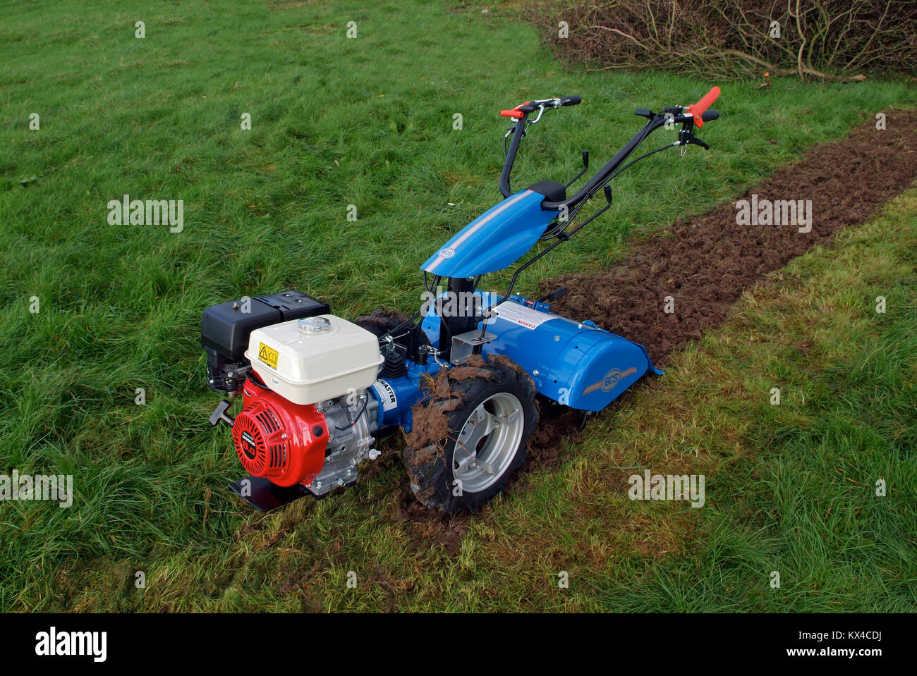 Rotavators in action in a country garden Stock Photo - Alamy