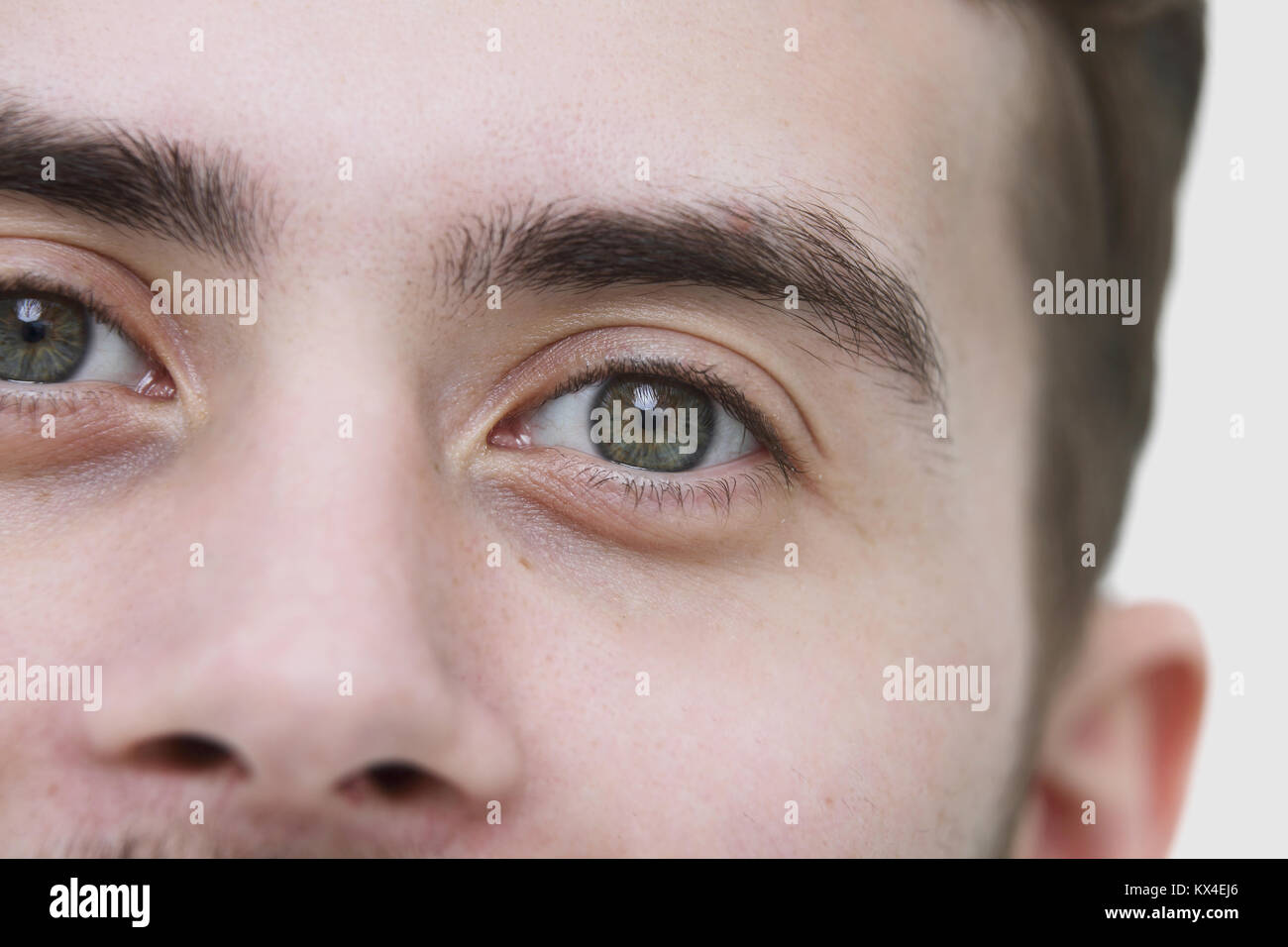 Crop of young man's face looking at camera Stock Photo - Alamy