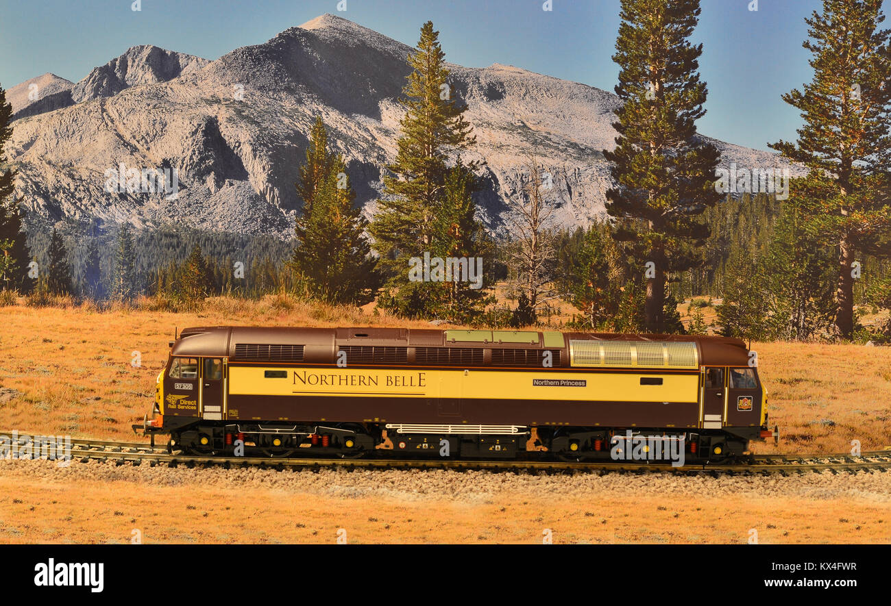 A model of a class 57 Diesel locomotive seat against a scenic backdrop ...
