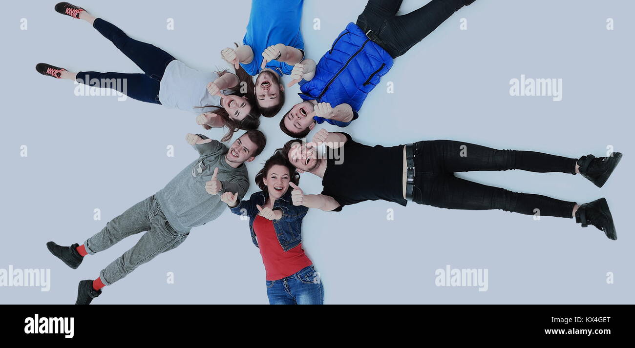 Young people lying down,gesturing thumb up sign Stock Photo - Alamy