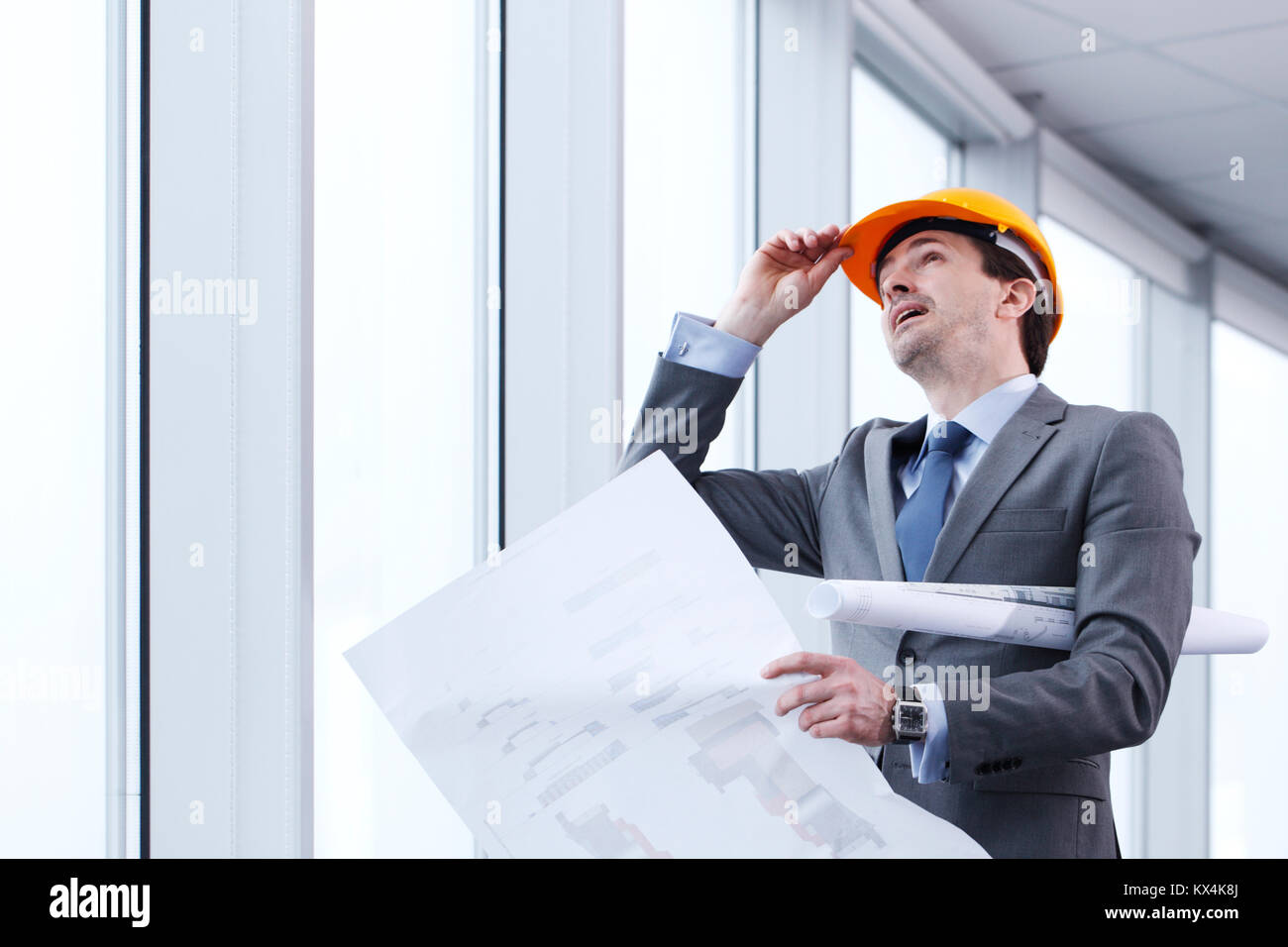 Architector in hardhat and business suit with construction plans Stock ...