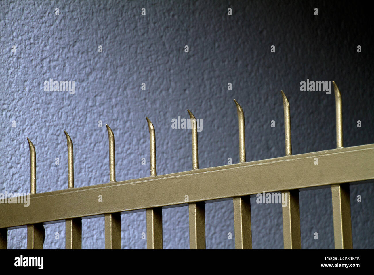 Golden spikes on gate near border Stock Photo - Alamy