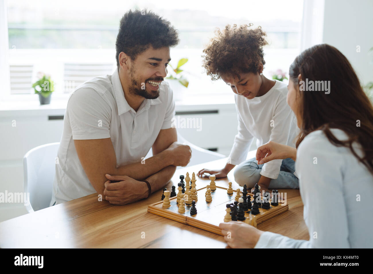 Happy family playing chess together at home Stock Photo - Alamy