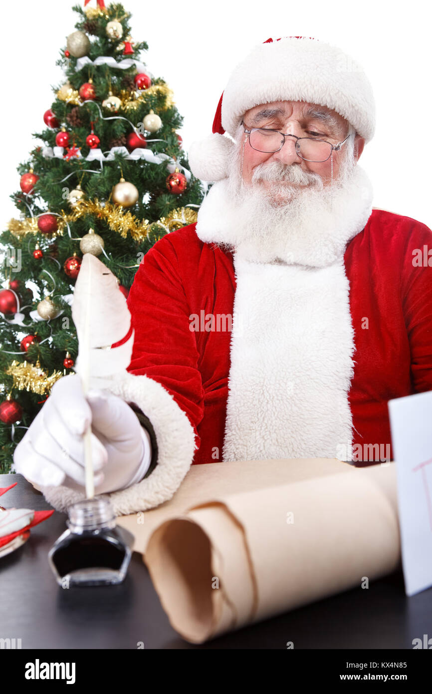 Santa Claus sitting at desk, writing a list of all the boys and girls ...