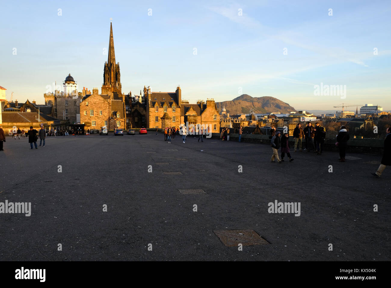Sunset over Edinburgh Castle courtyard with tourists in Old Town area ...