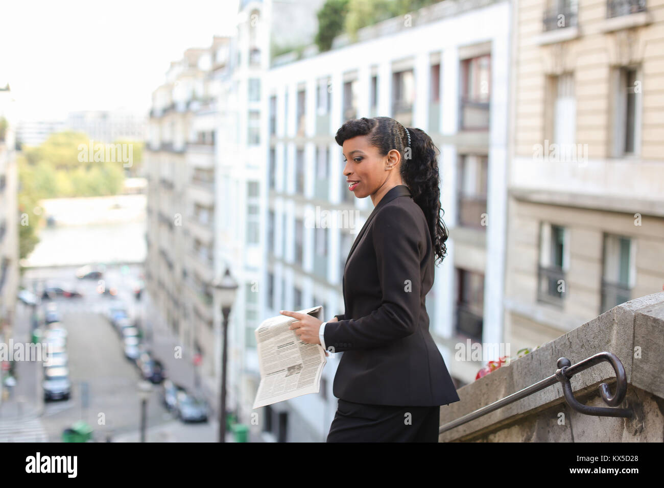 Half Nigerian reporter looking at cam with newspaper on balcony Stock ...