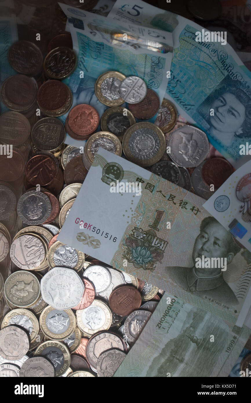 DONATIONS: Notes and coins of various currencies in a donation box ...