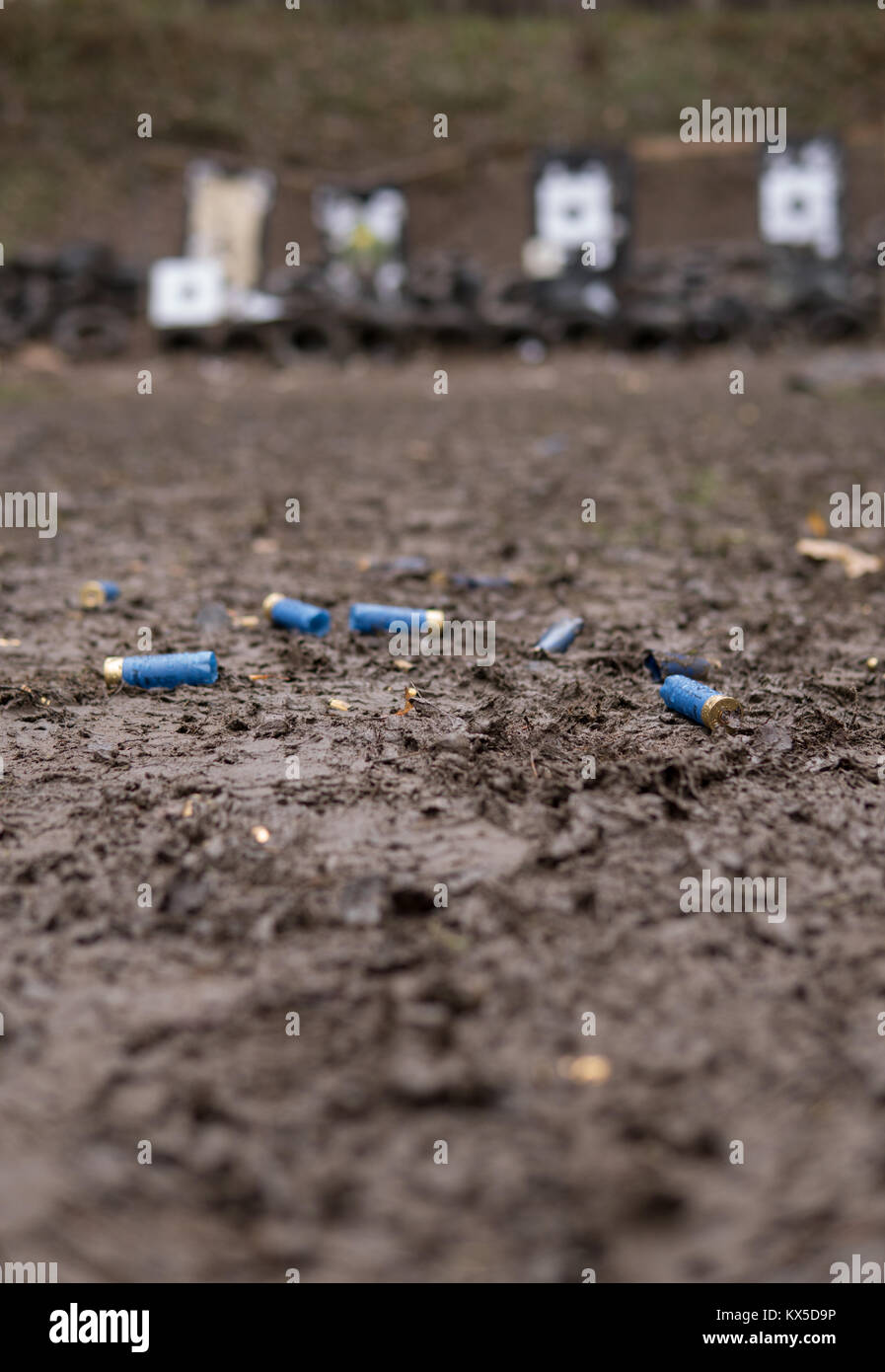 close up of blue shells of ammunition lying on the ground with shooting ...