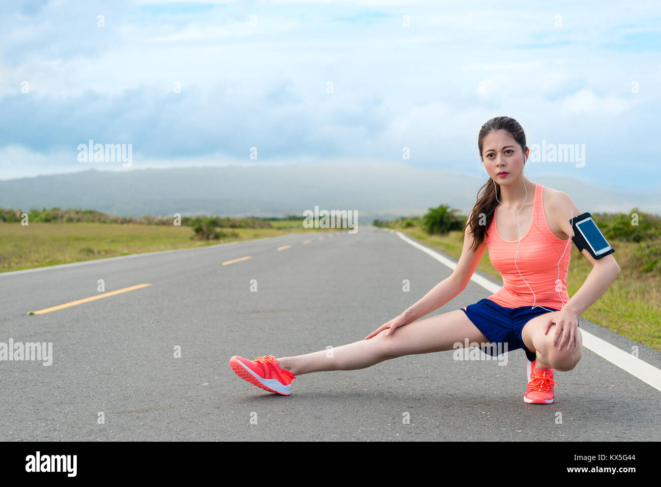 confident pretty marathon player woman doing lunge posture on road to ...