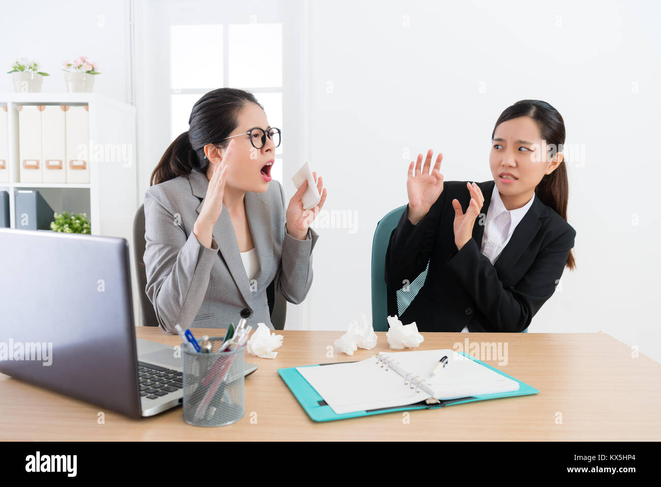 attractive female company manager sneezing and woman co-worker looking ...