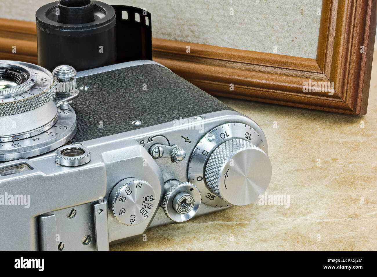 retro camera, negative films and wooden photo frame on paper background ...