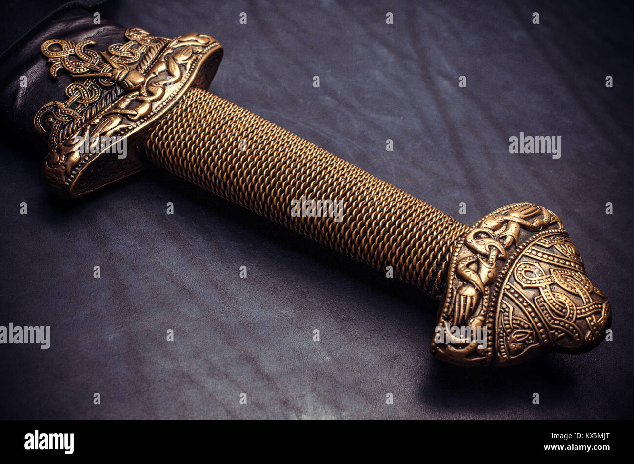 The magnificent bronze handle of the sword in a spiral braid on a black ...
