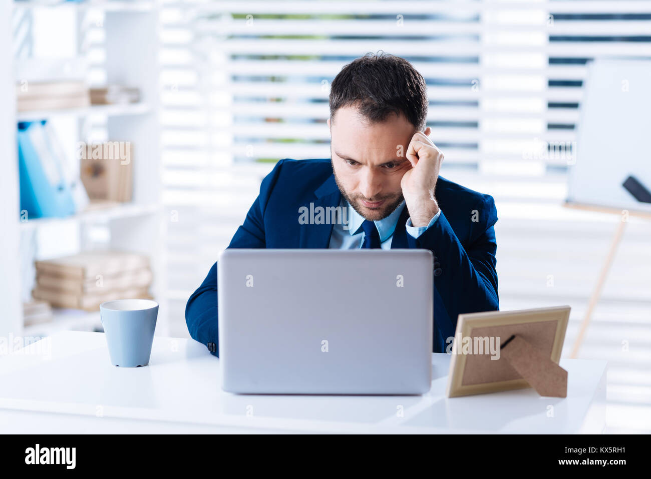 Clever experienced manager looking at the screen while working Stock ...