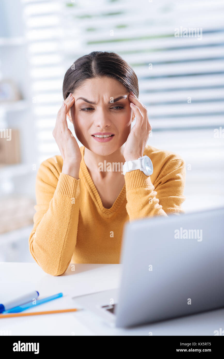 Exhausted worker touching the forehead while experiencing terrible ...