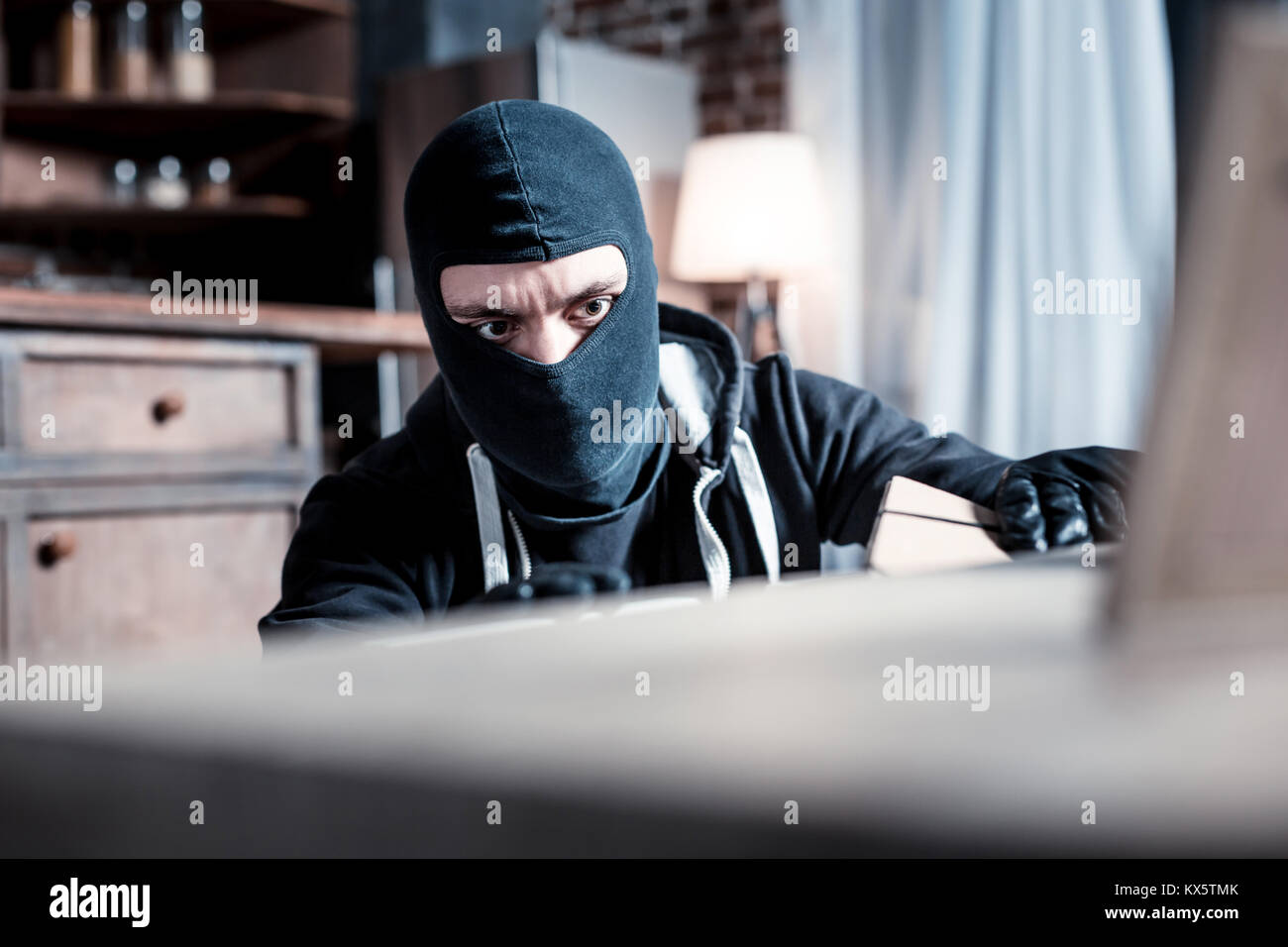 Concentrated robber rifling and wearing uniform Stock Photo - Alamy