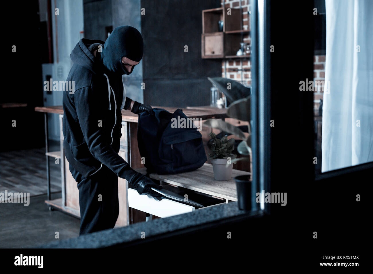 Cruel burglar stealing a laptop from the table Stock Photo - Alamy