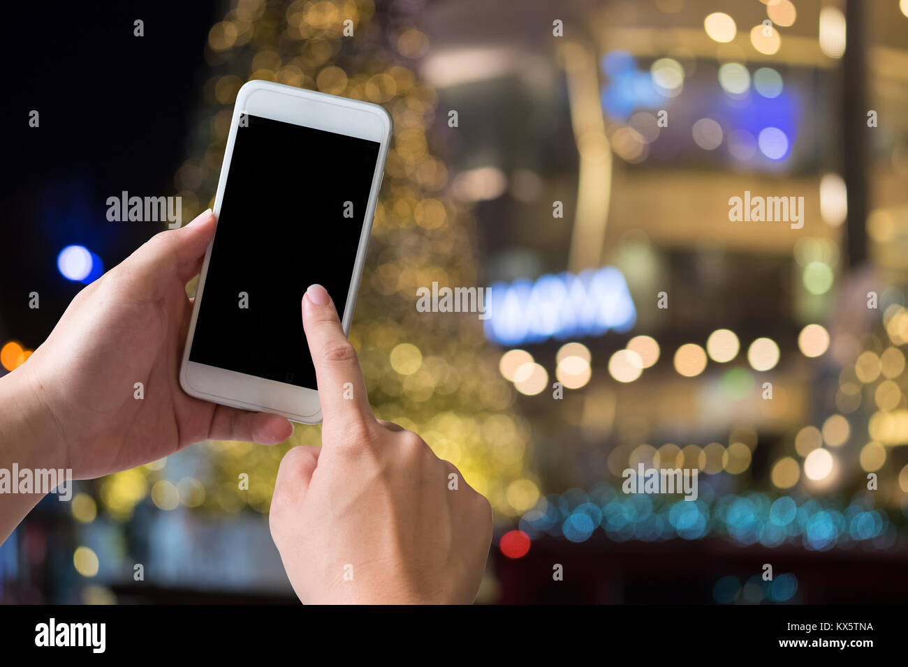 Smartphone on hand with bokeh night street city Stock Photo - Alamy