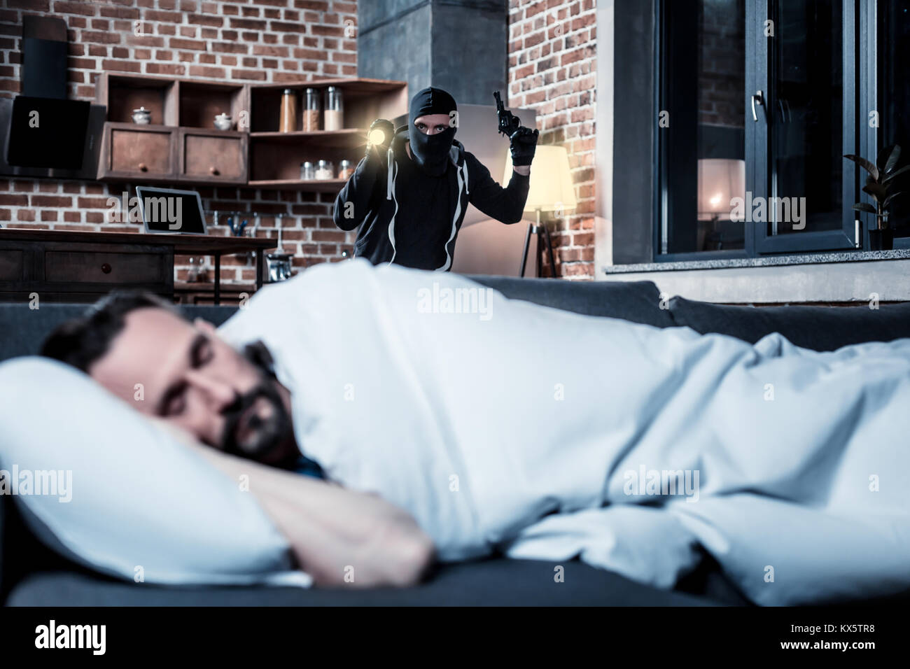 Masked criminal with a torch and gun Stock Photo - Alamy