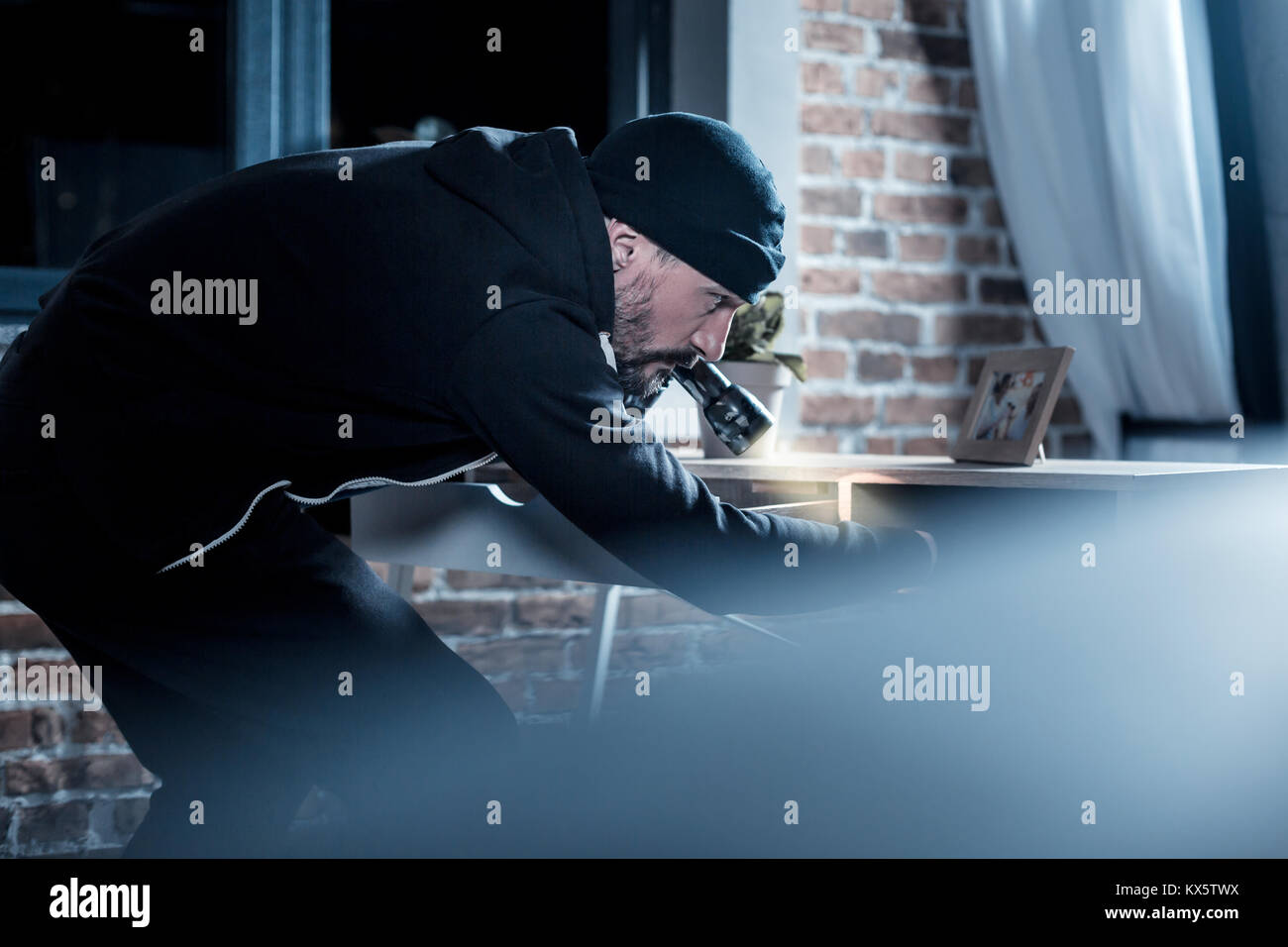 Professional burglar looking for documents in the table Stock Photo - Alamy