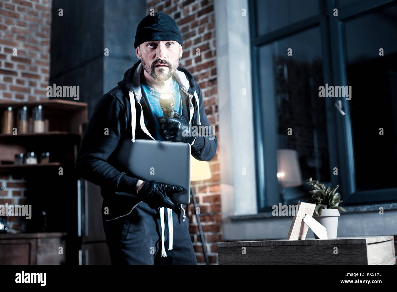 Furious burglar stealing laptop at night Stock Photo - Alamy