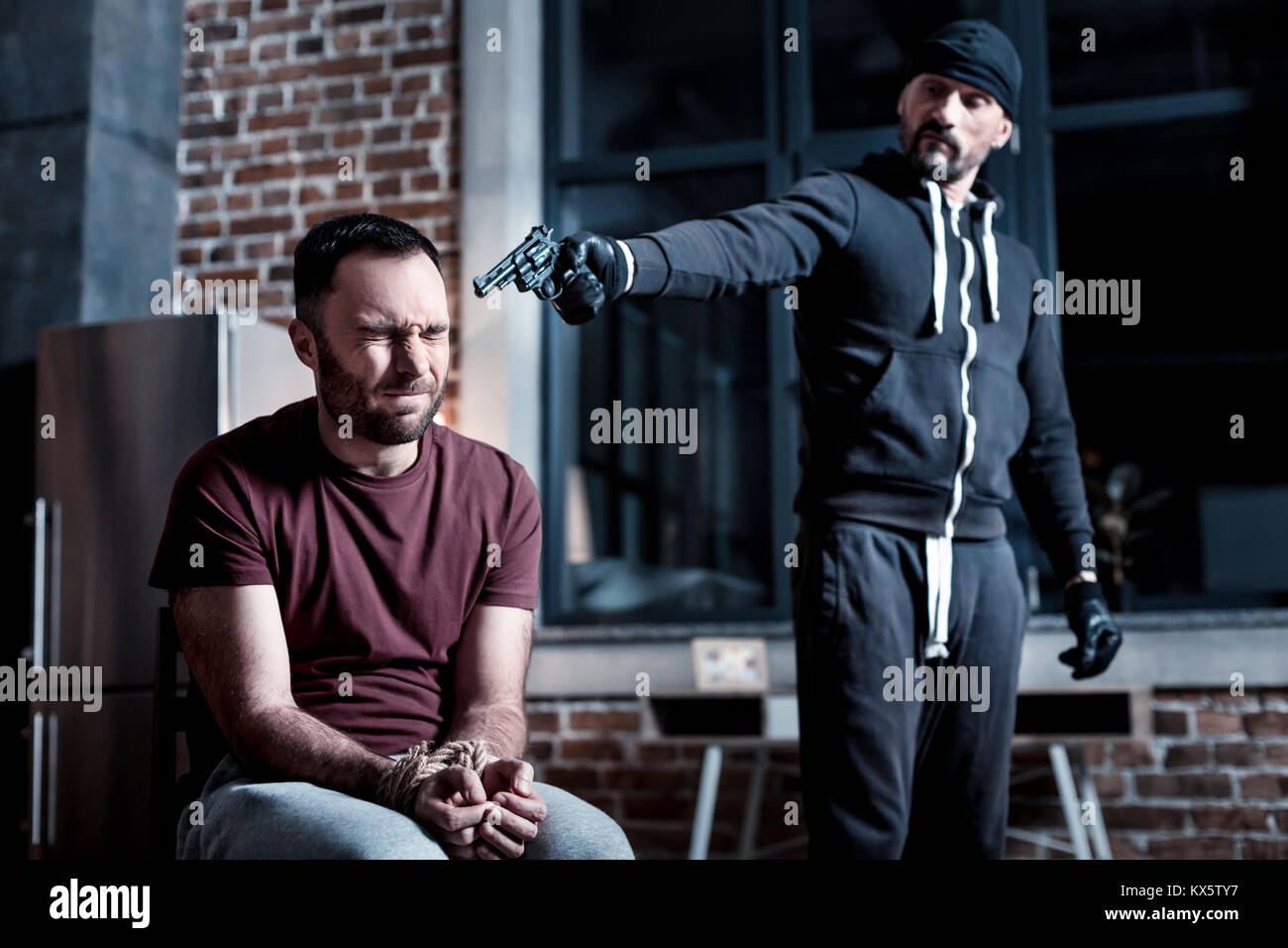 Frightened man sitting with his hands tied Stock Photo - Alamy