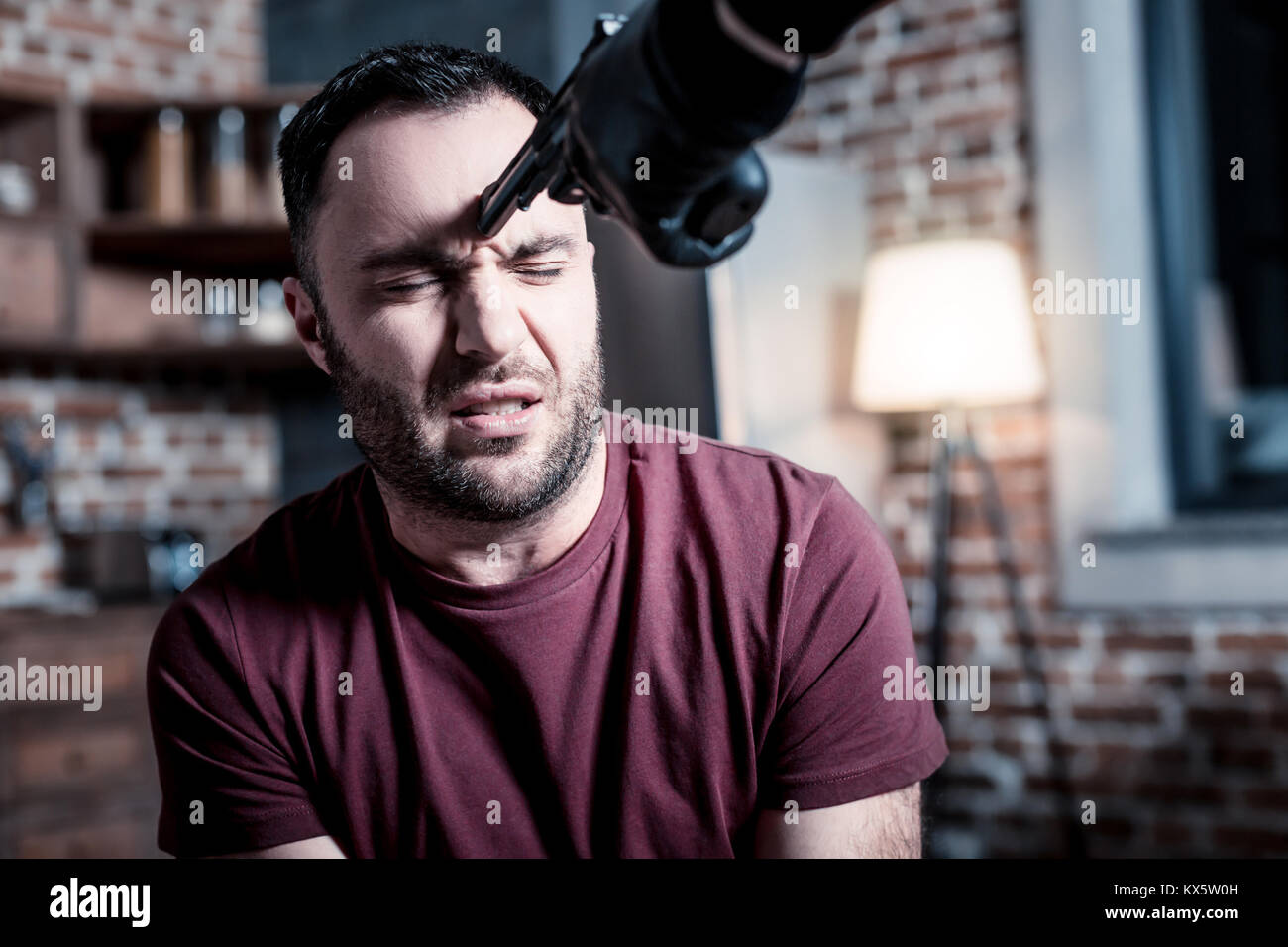 Frightened man having gun at his head Stock Photo - Alamy