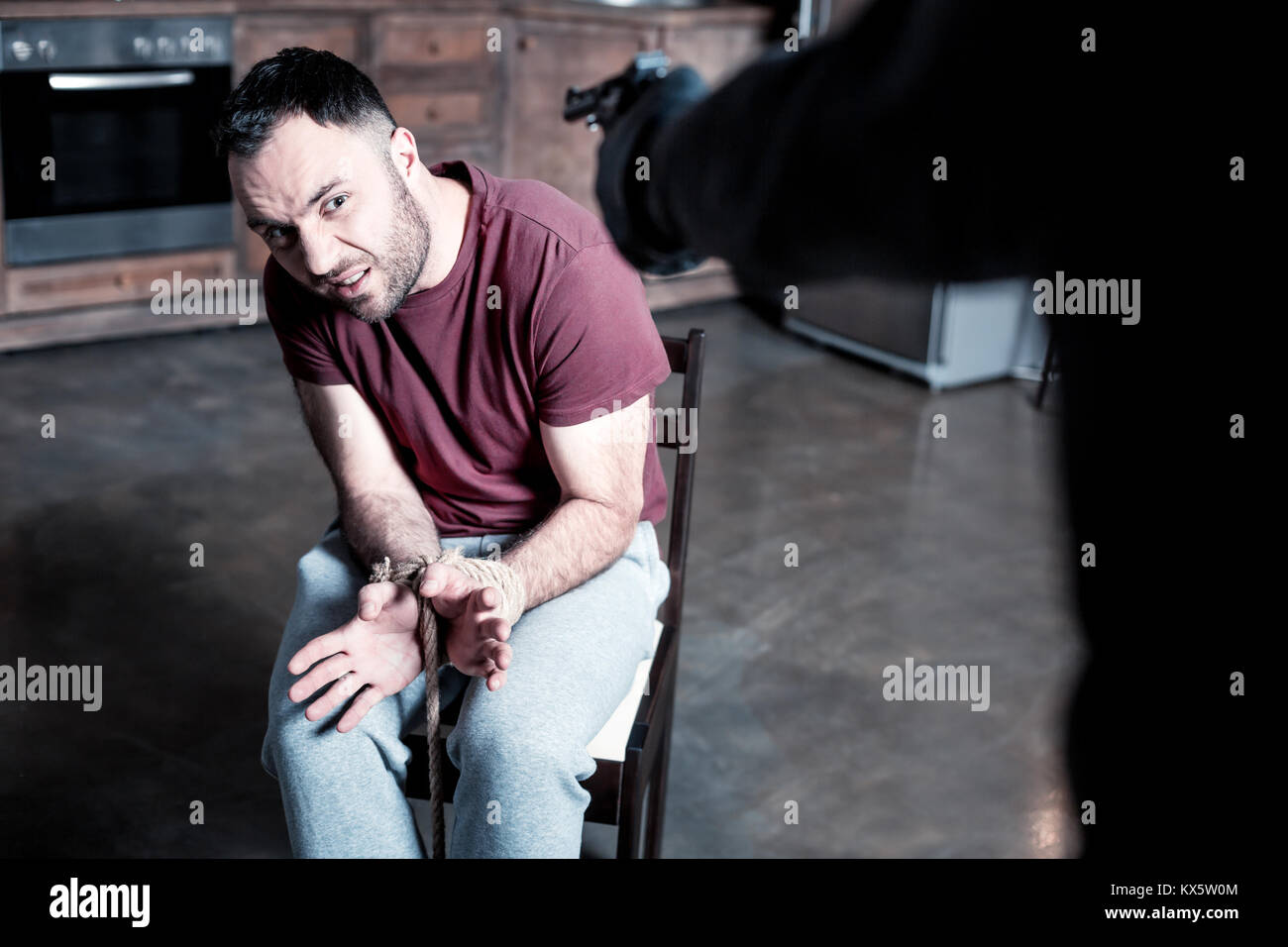 Alarmed shocked man sitting with his hands tied Stock Photo - Alamy