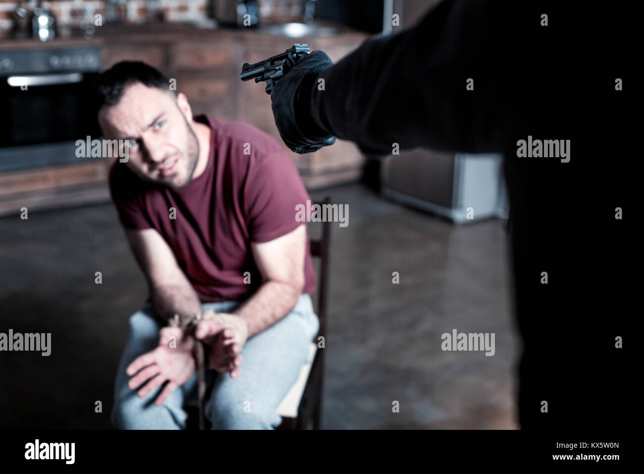 Intimidated man and a killer with a gun Stock Photo - Alamy