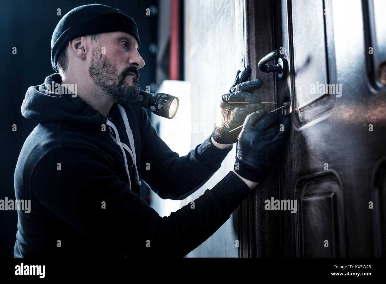 Professional robber unlocking the door Stock Photo - Alamy